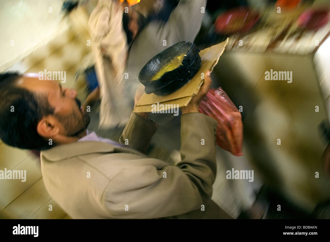 A waiter carries a Yemeni traditional stewed meat dish known as "Salta ...