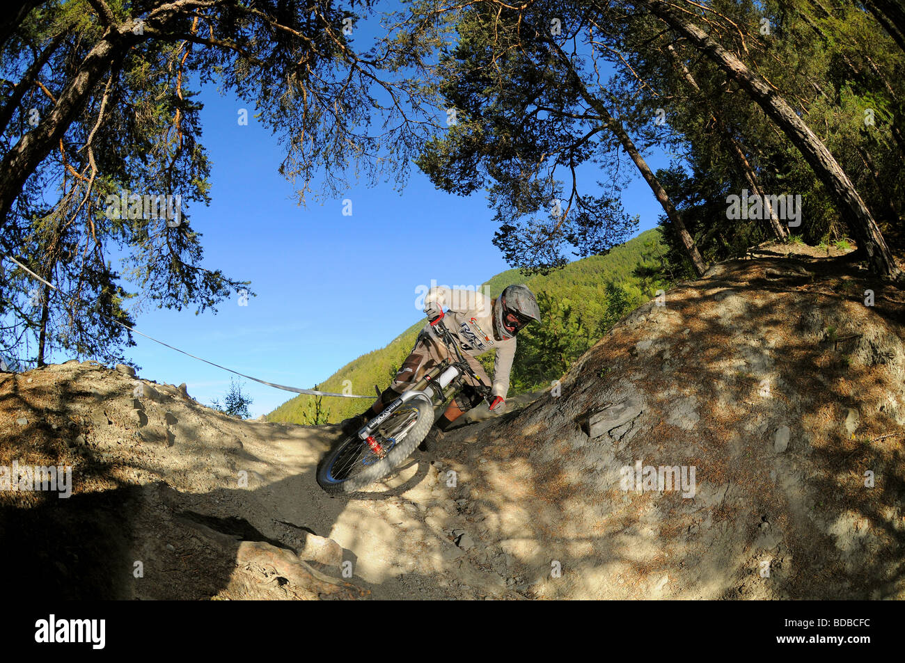 A mountain biker rides a rocky downhill trail through trees in Pila in ...
