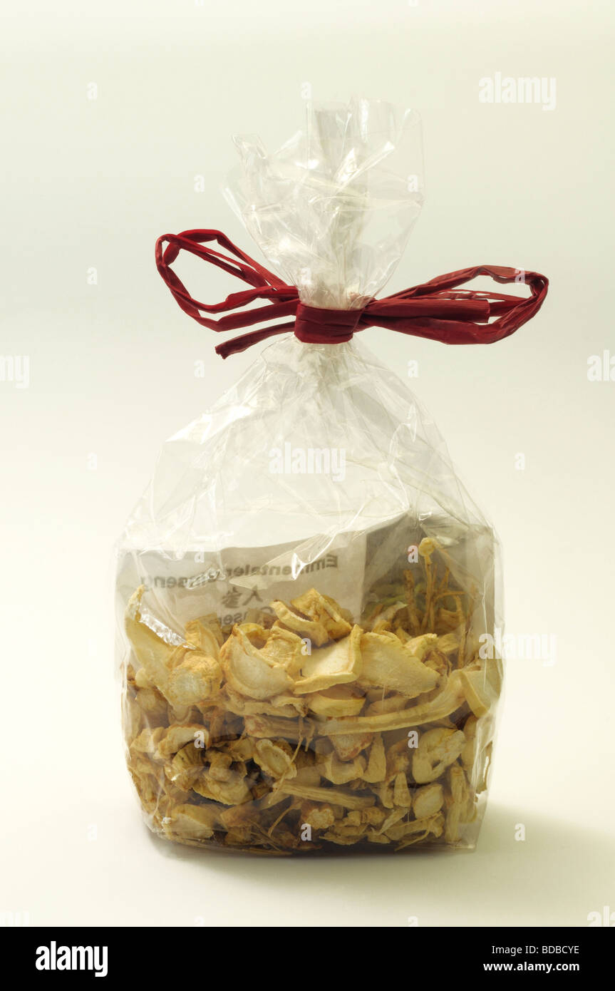 Ginseng (Panax ginseng). Chopped dried root in transparent bag, studio ...