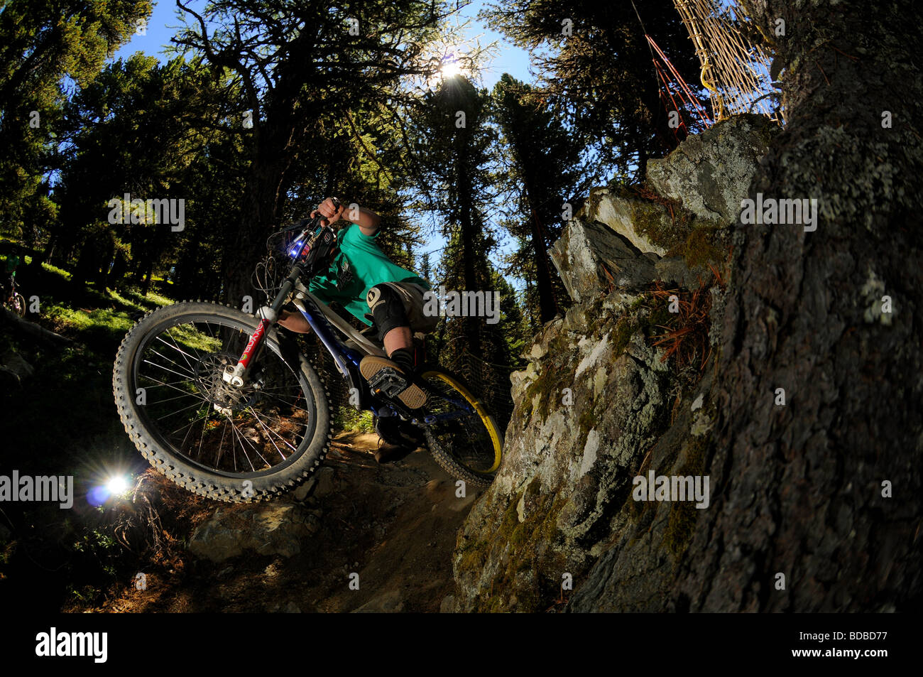 A mountain biker rides a rocky downhill trail through trees in Pila in ...