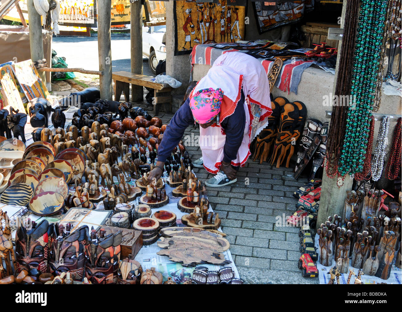 An African sales woman arranging art and craft items for display in her ...