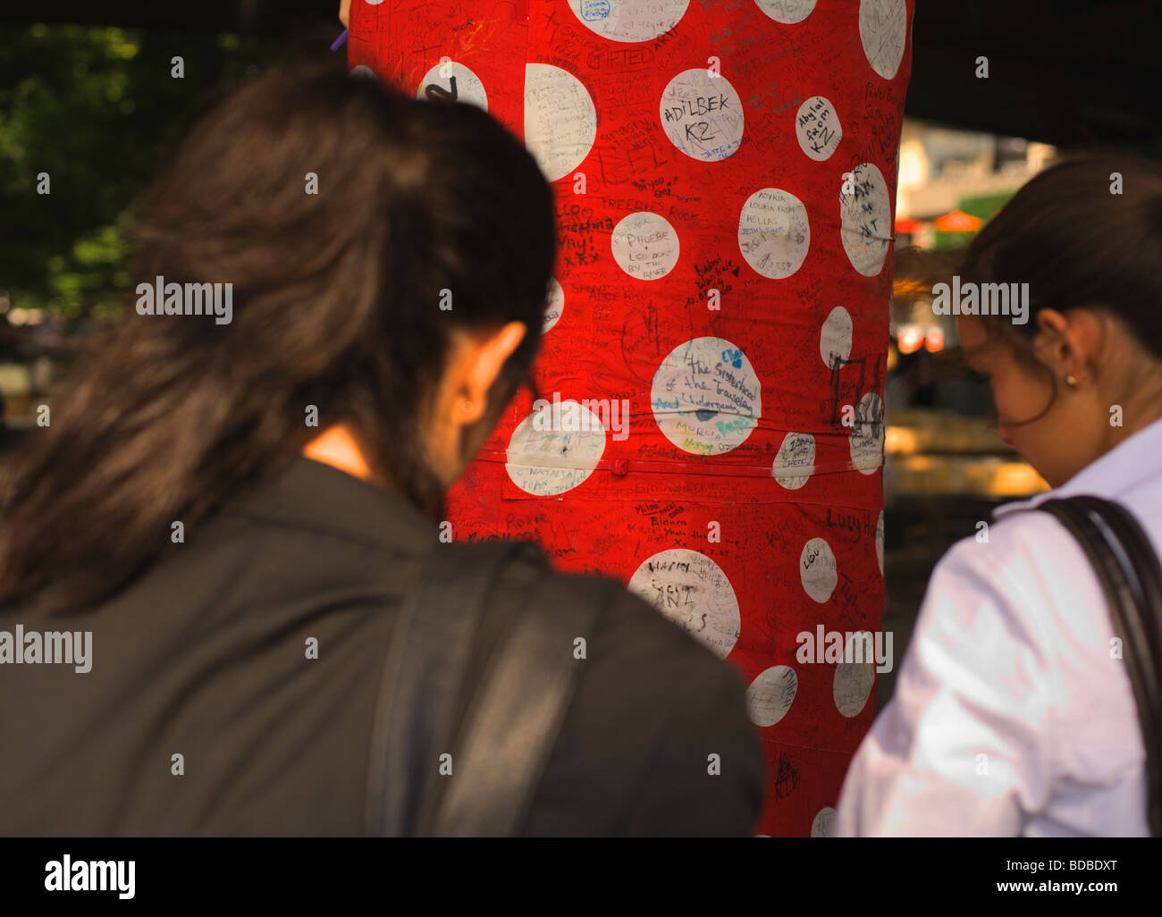 Tourists writing messages on wrapped tree trunks - South Bank, London ...
