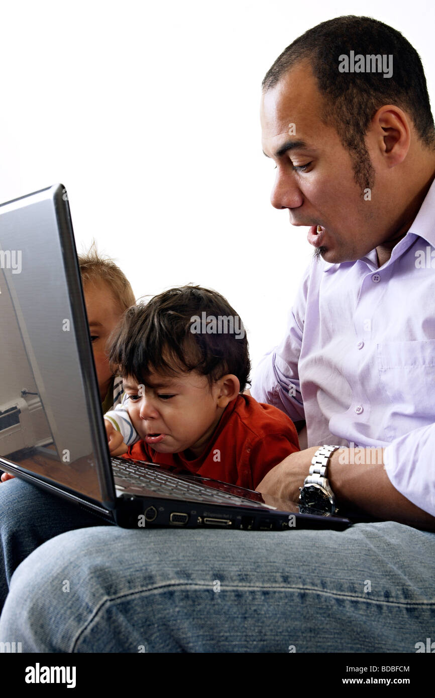 father showing his two sons laptop computer Stock Photo - Alamy