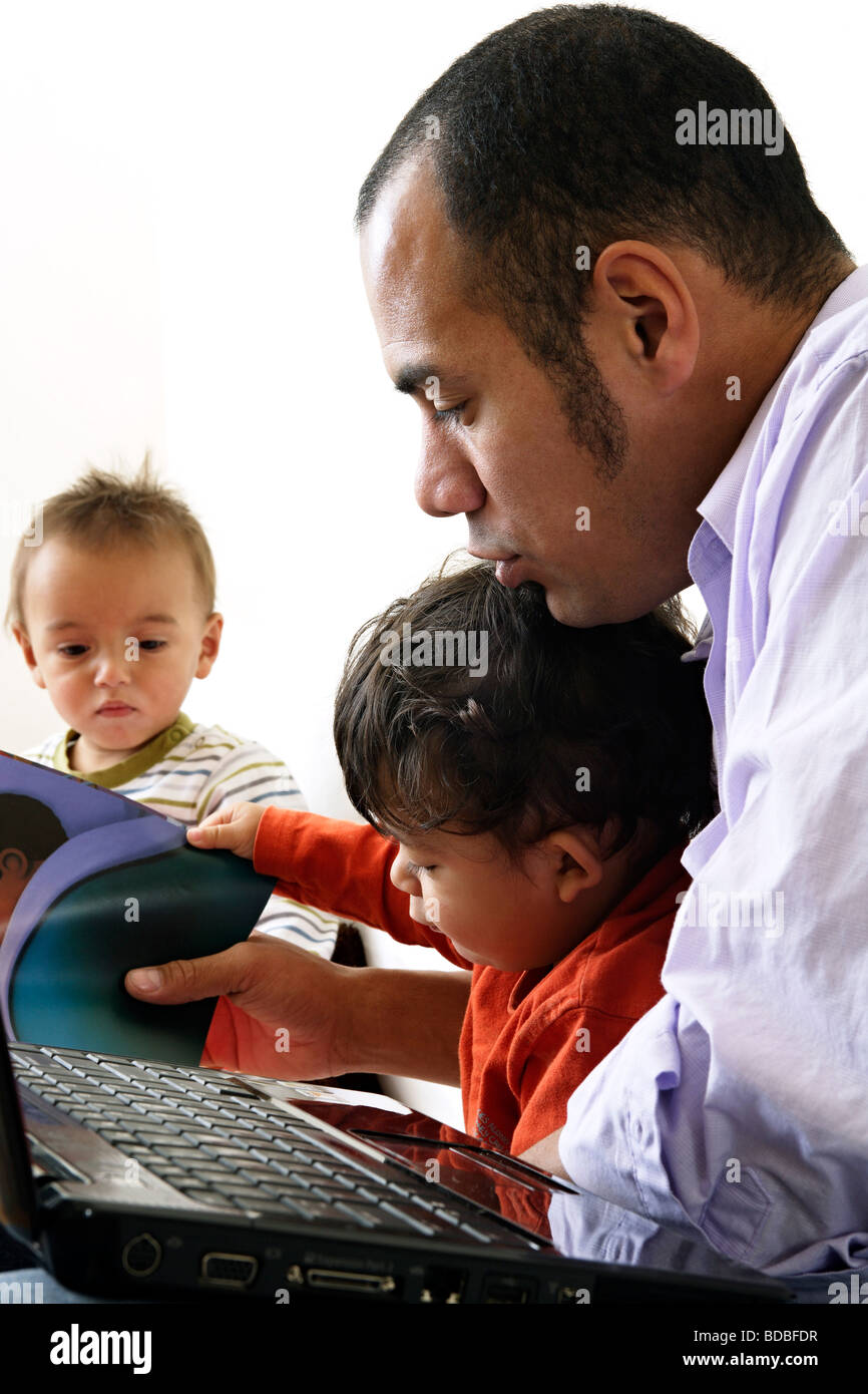 father showing his two sons laptop computer Stock Photo - Alamy