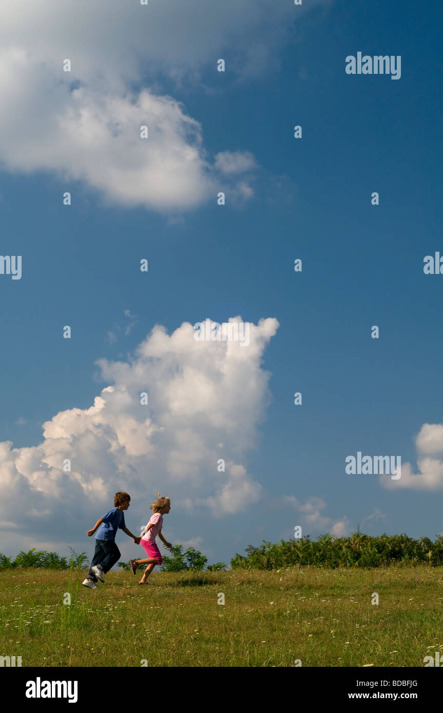 Children playing and running on meadow against blue sky Stock Photo - Alamy