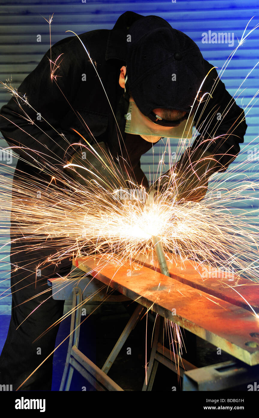 factory worker creating sparks whilst grinding metal Stock Photo - Alamy