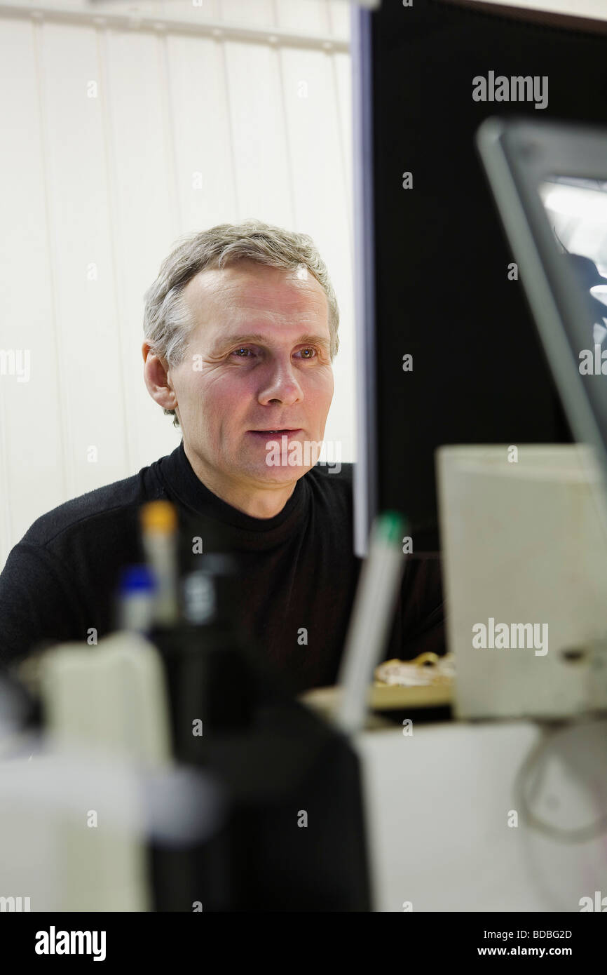 portrait of worker at computer repair shop looking at monitor Stock ...