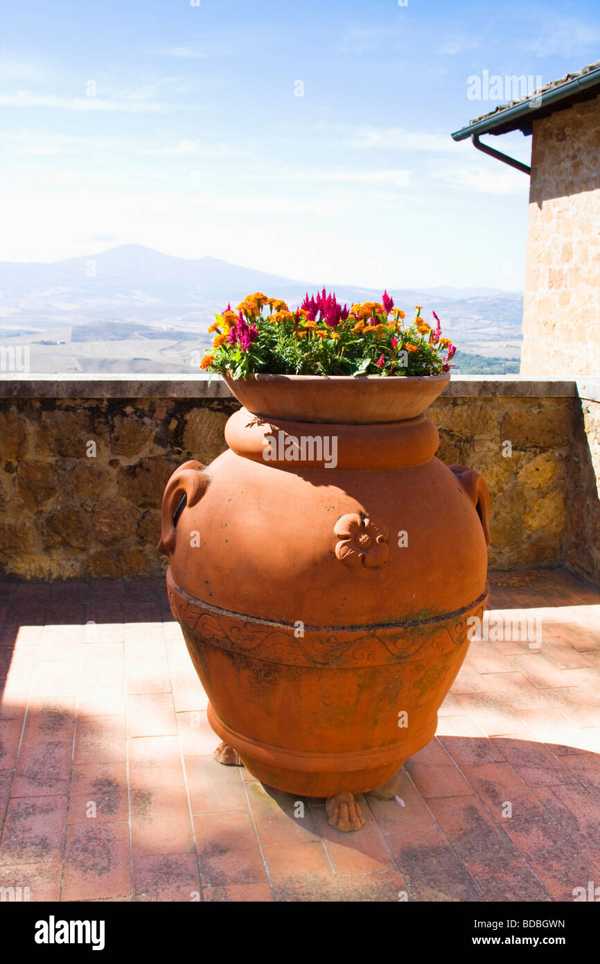 Terracotta pot with colorful flowers on a Tuscan terrace overlooking ...