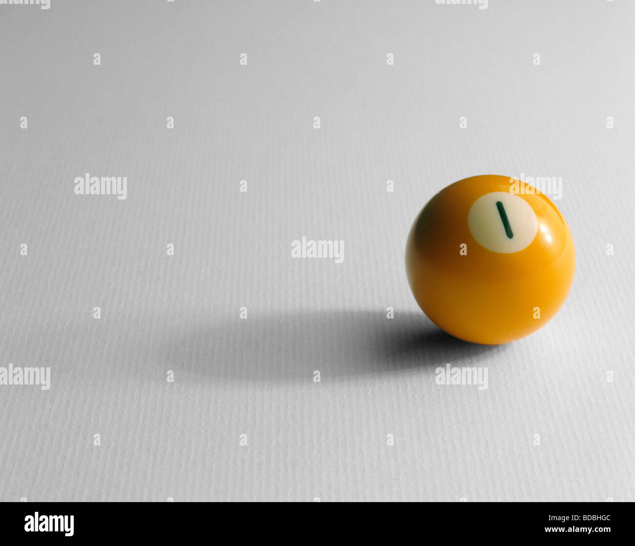 Single yellow #1 pool ball sitting on white textured background with ...
