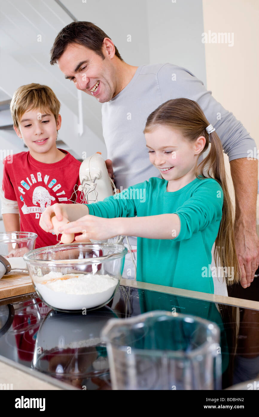 father and his two children making cake together Stock Photo - Alamy