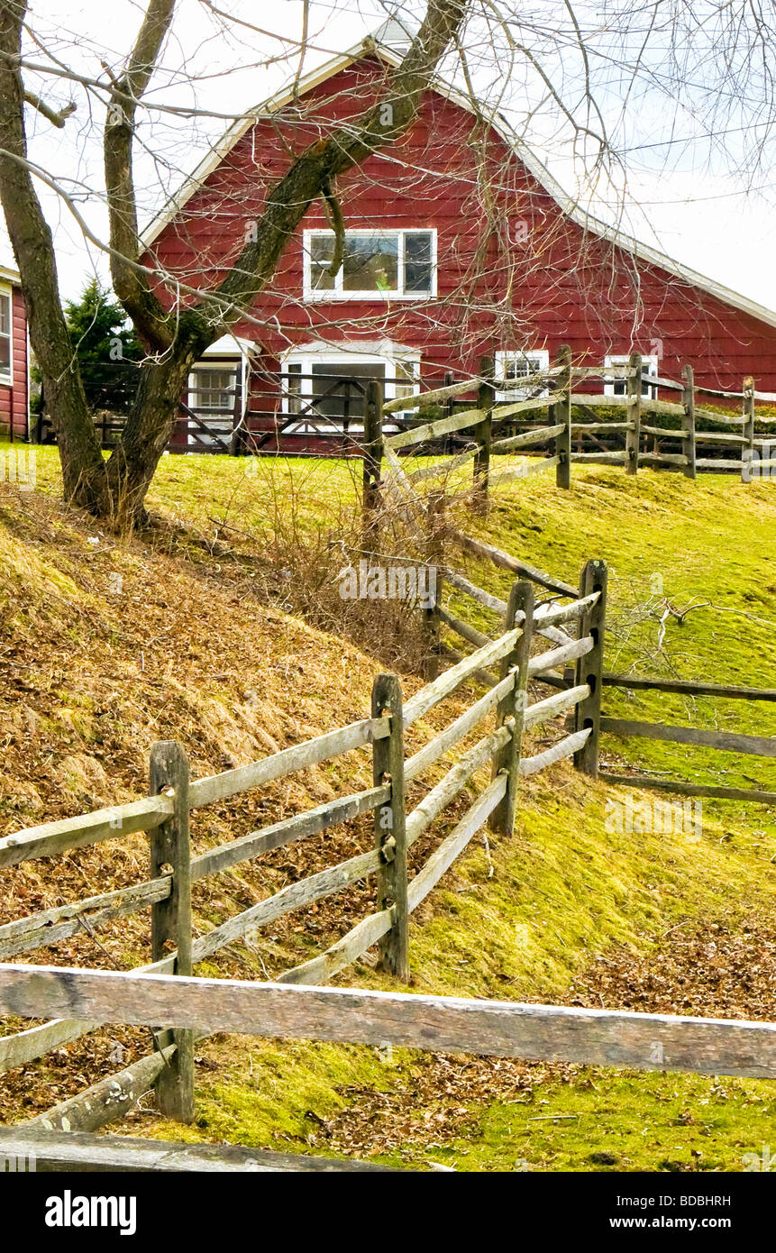 Farm scene with red barn in background and wood fence leading into the ...