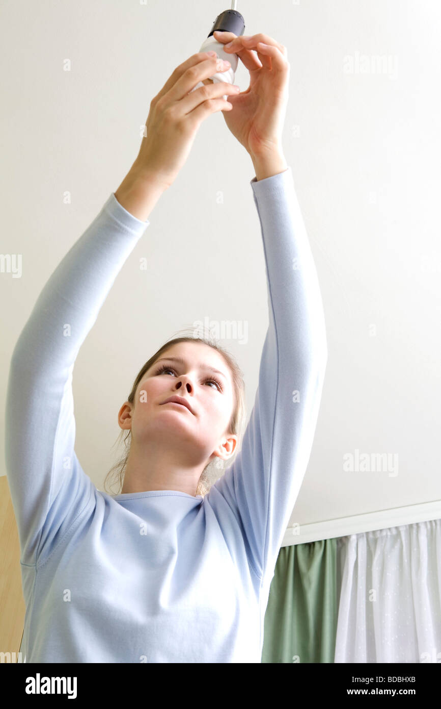 young woman fixing low energy light bulb Stock Photo - Alamy