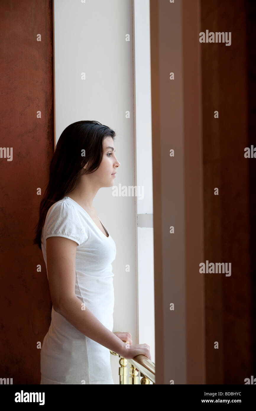 portrait of teenage girl looking out of window Stock Photo - Alamy