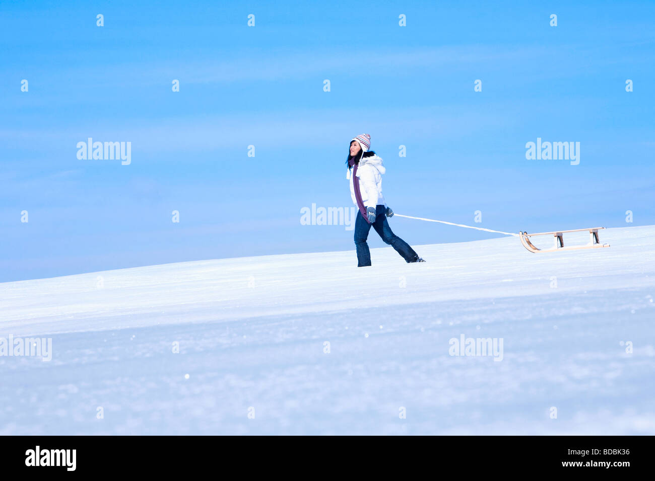 young asian woman in winter pulling sledge through snow Stock Photo - Alamy