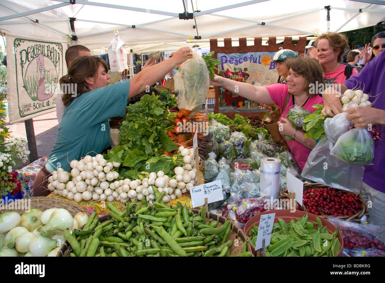 Customers purchase fresh vegetables from a farmers market in Boise ...