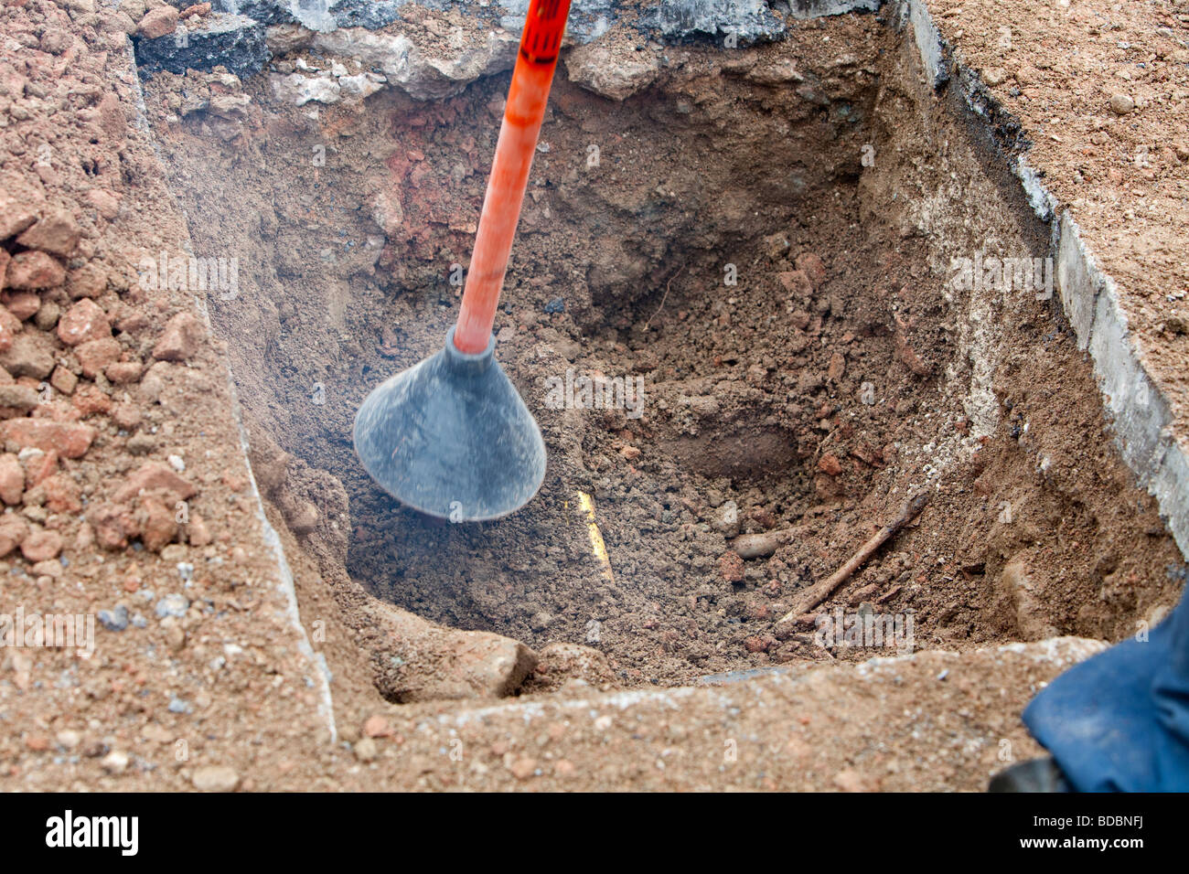 A British Gas worker using a compressed air soil picker to loosen soil ...
