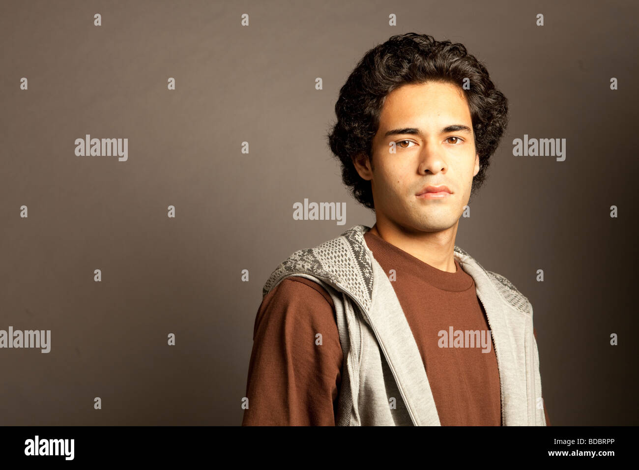 Portrait of Hispanic male with serious expression looking at camera ...