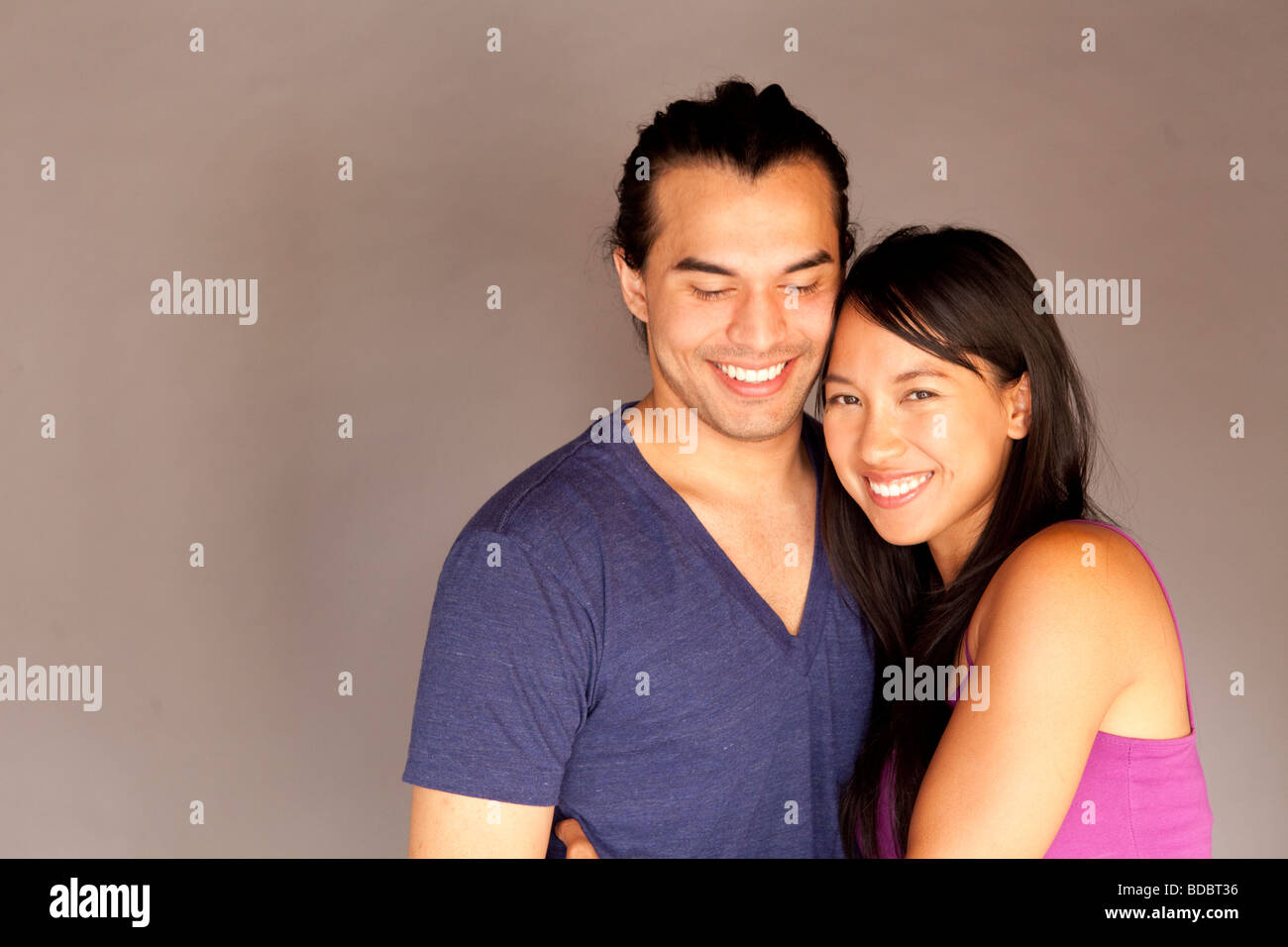 Portrait of Filipino female and ethnic male couple holding each other ...