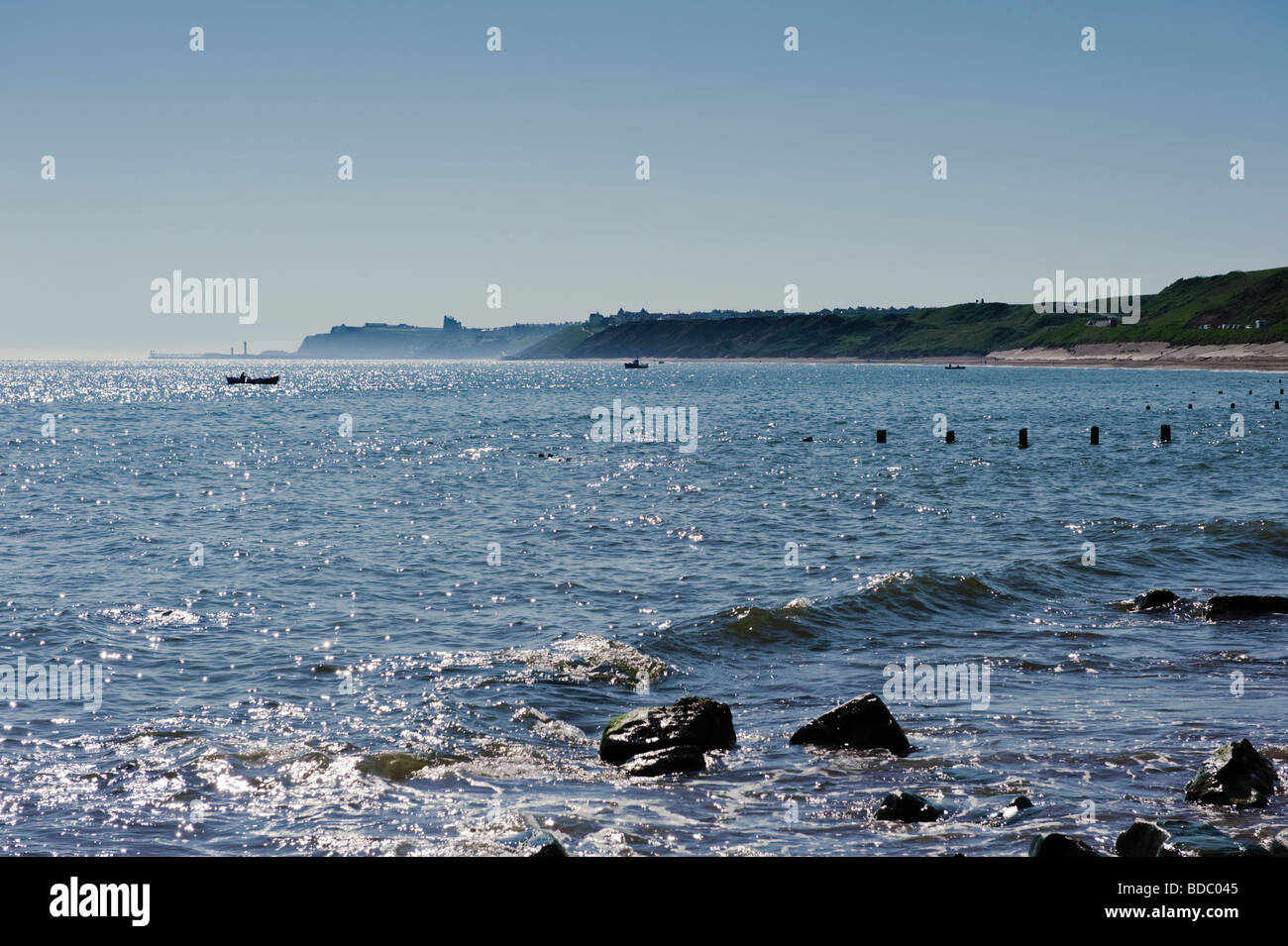 View from Sandsend of Whitby Abbey and harbour, as the last of the sea ...
