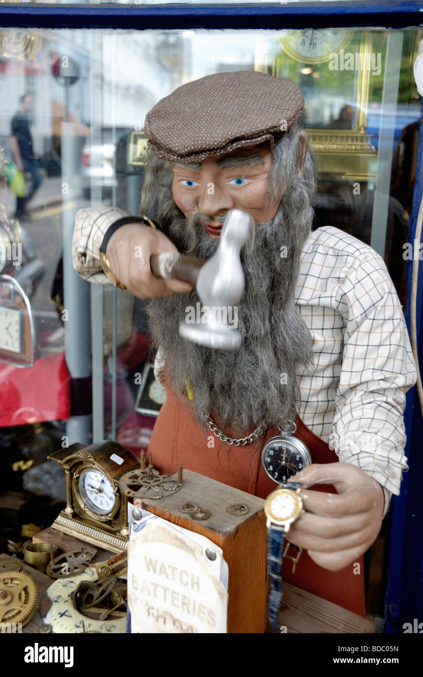 Watchmaker puppet mending a watch Stock Photo - Alamy