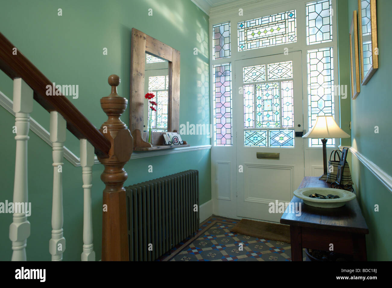 Stained glass windows and half glazed door in traditional green hall ...