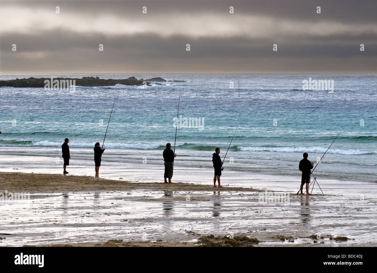 Approaching storm clouds as anglers fish off the beach at Sennen in ...
