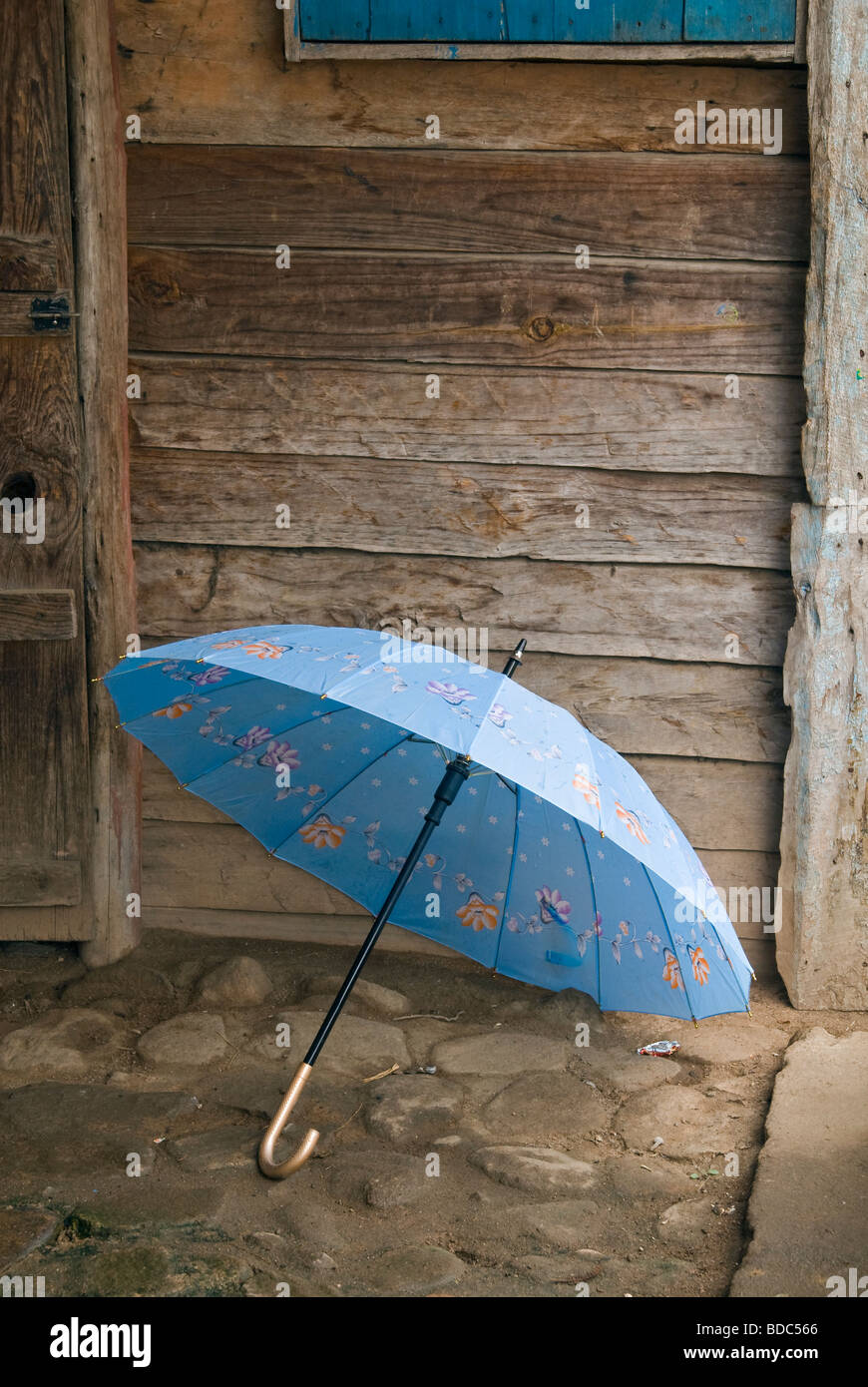 Open blue umbrella on the porch of a log cabin Stock Photo - Alamy