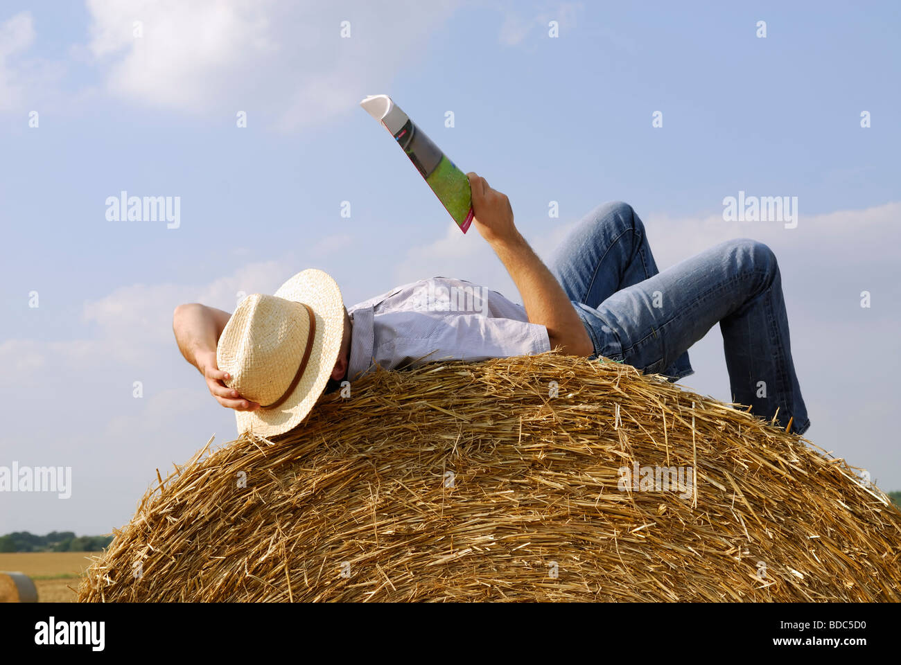 young man reading on top of a straw bale Stock Photo - Alamy