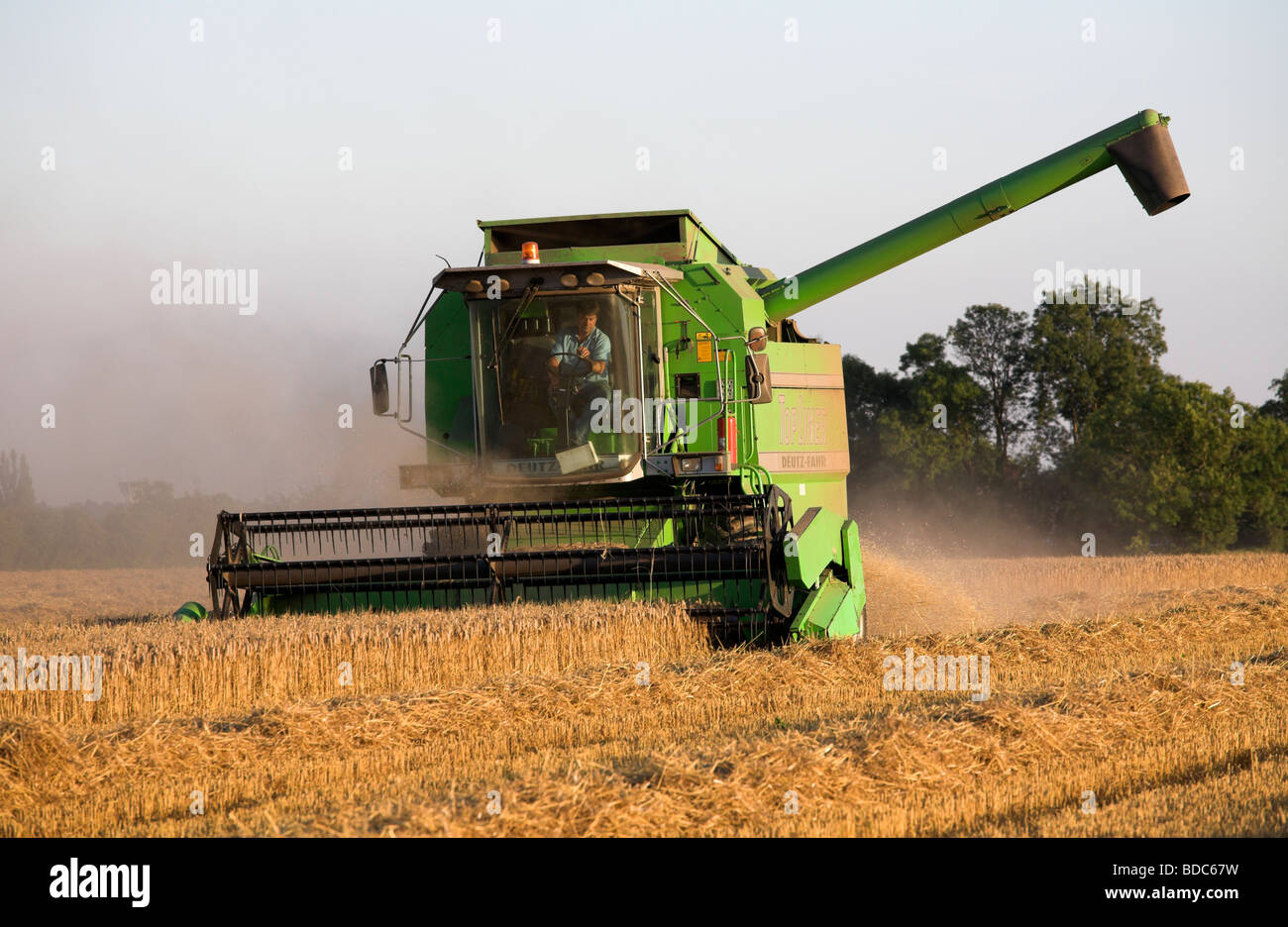 Modern combine harvester harvesting a field of wheat Stock Photo - Alamy