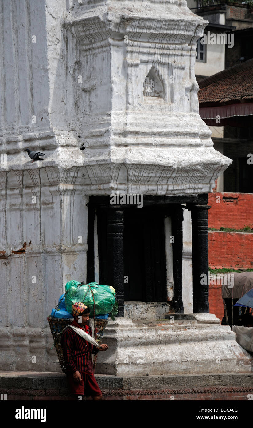 man carry carrying heavy load kamdev temple shrine buddhist white domed ...