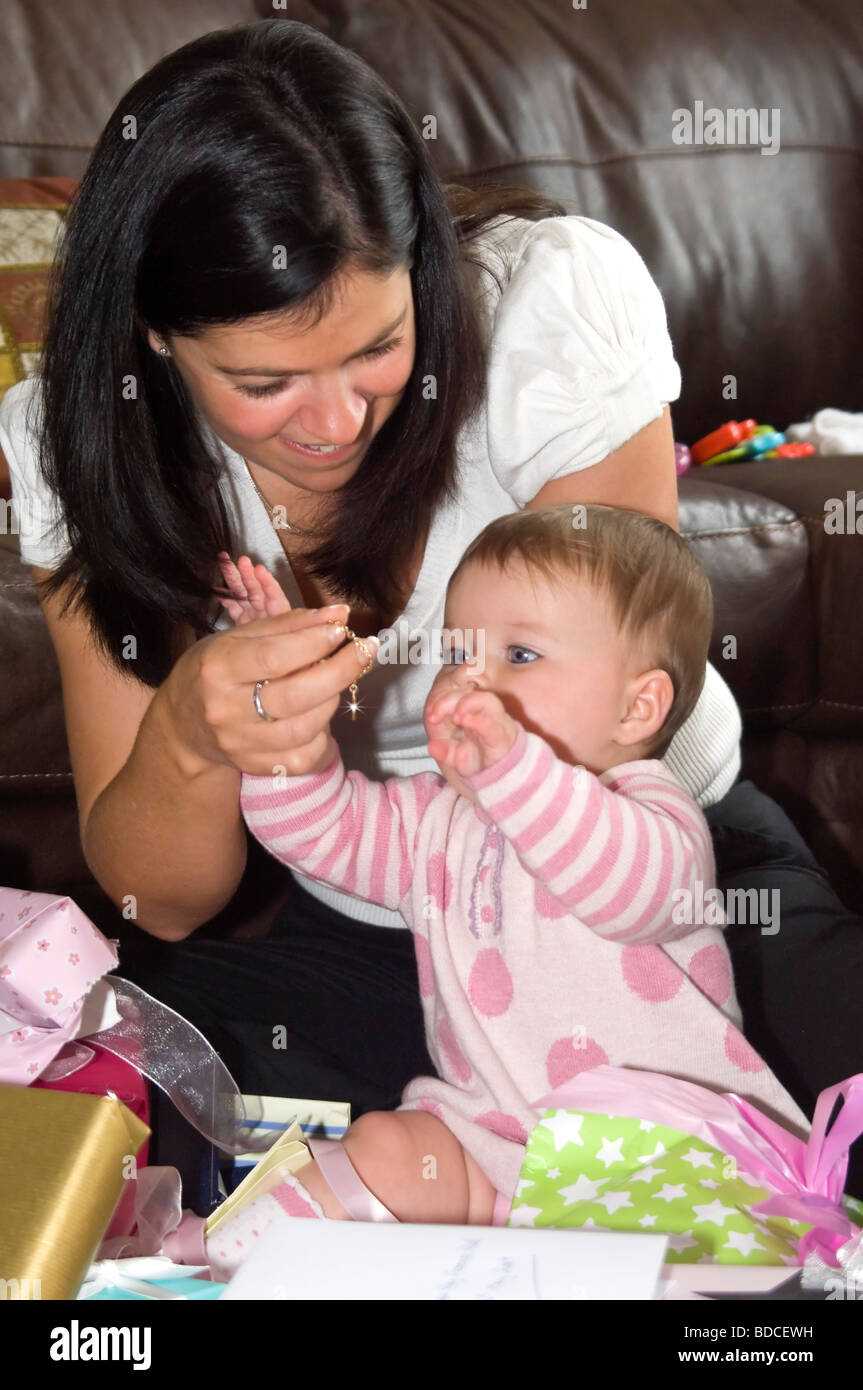 Vertical portrait of a proud mother showing her gorgeous baby girl one ...