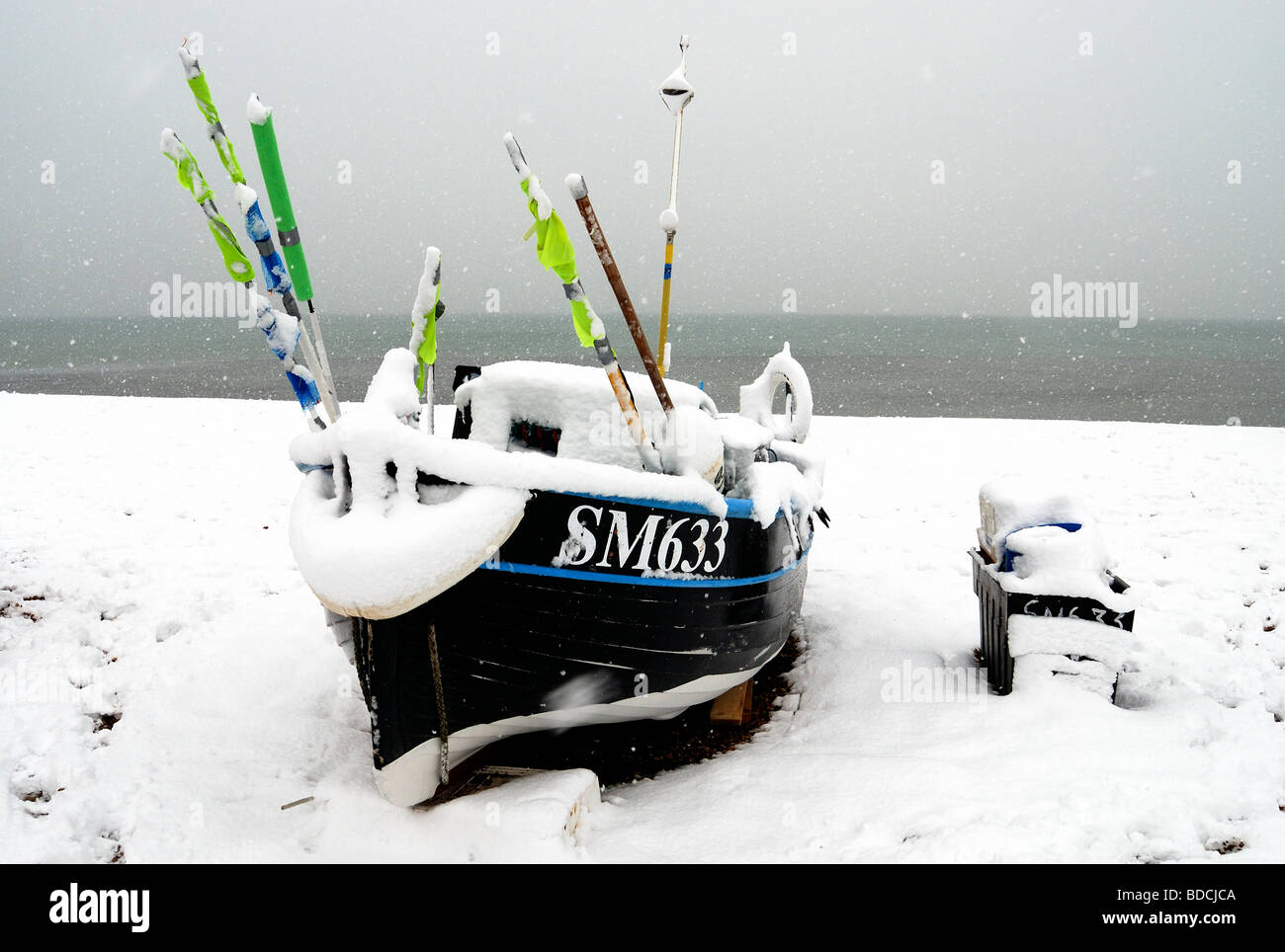 A snow covered fishing boat on a beach Stock Photo - Alamy