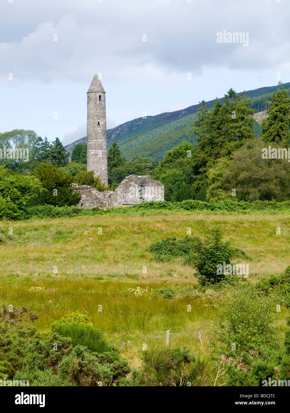 The round tower amongst ruins of a monastic settlement at Glendalough ...