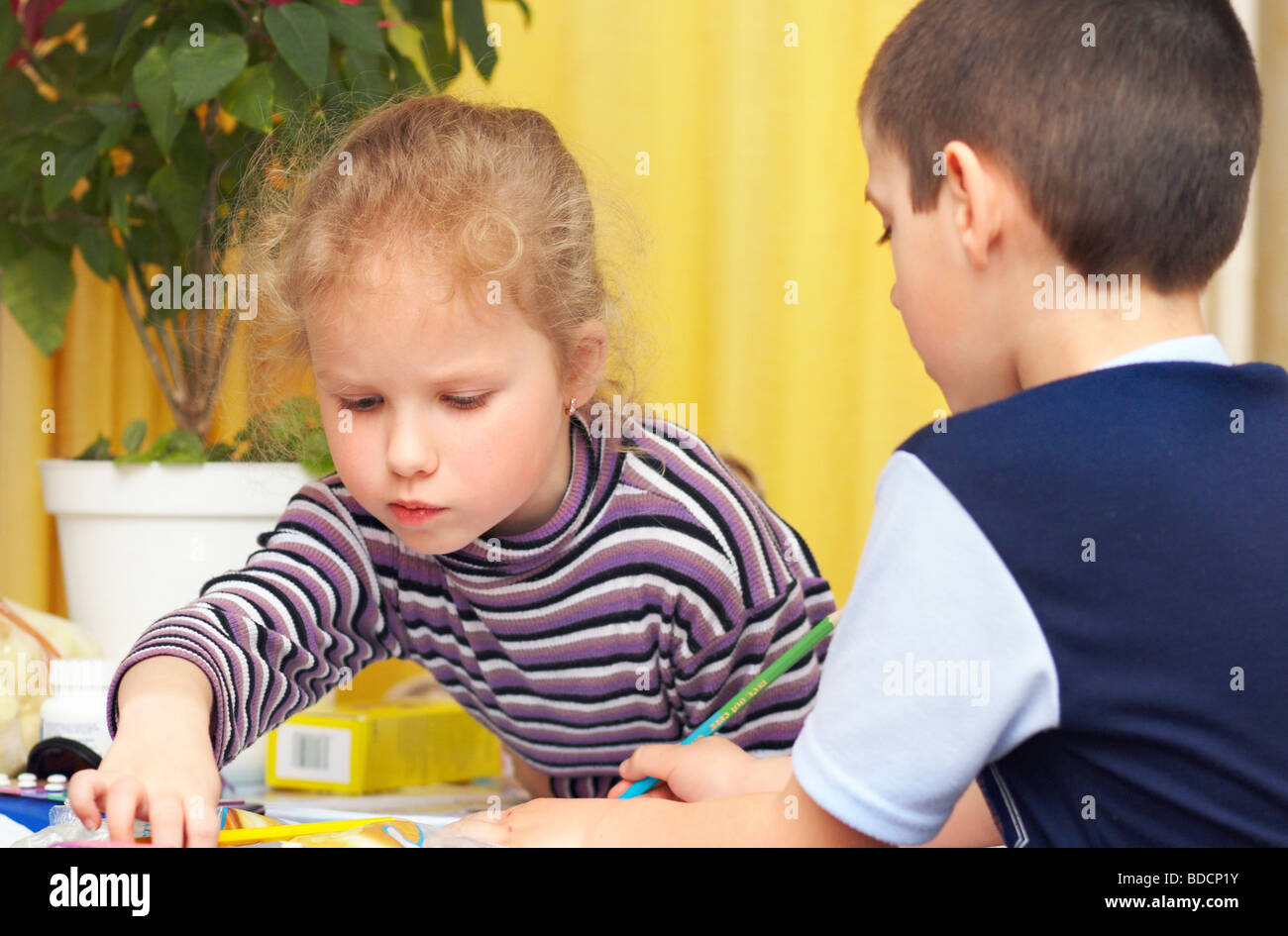 Young children draw in pencil at table Stock Photo - Alamy