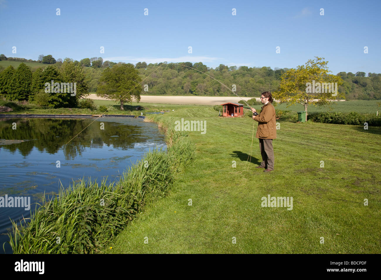 Fisherman catching a trout at Meon Springs Trout Fishery Hampshire ...