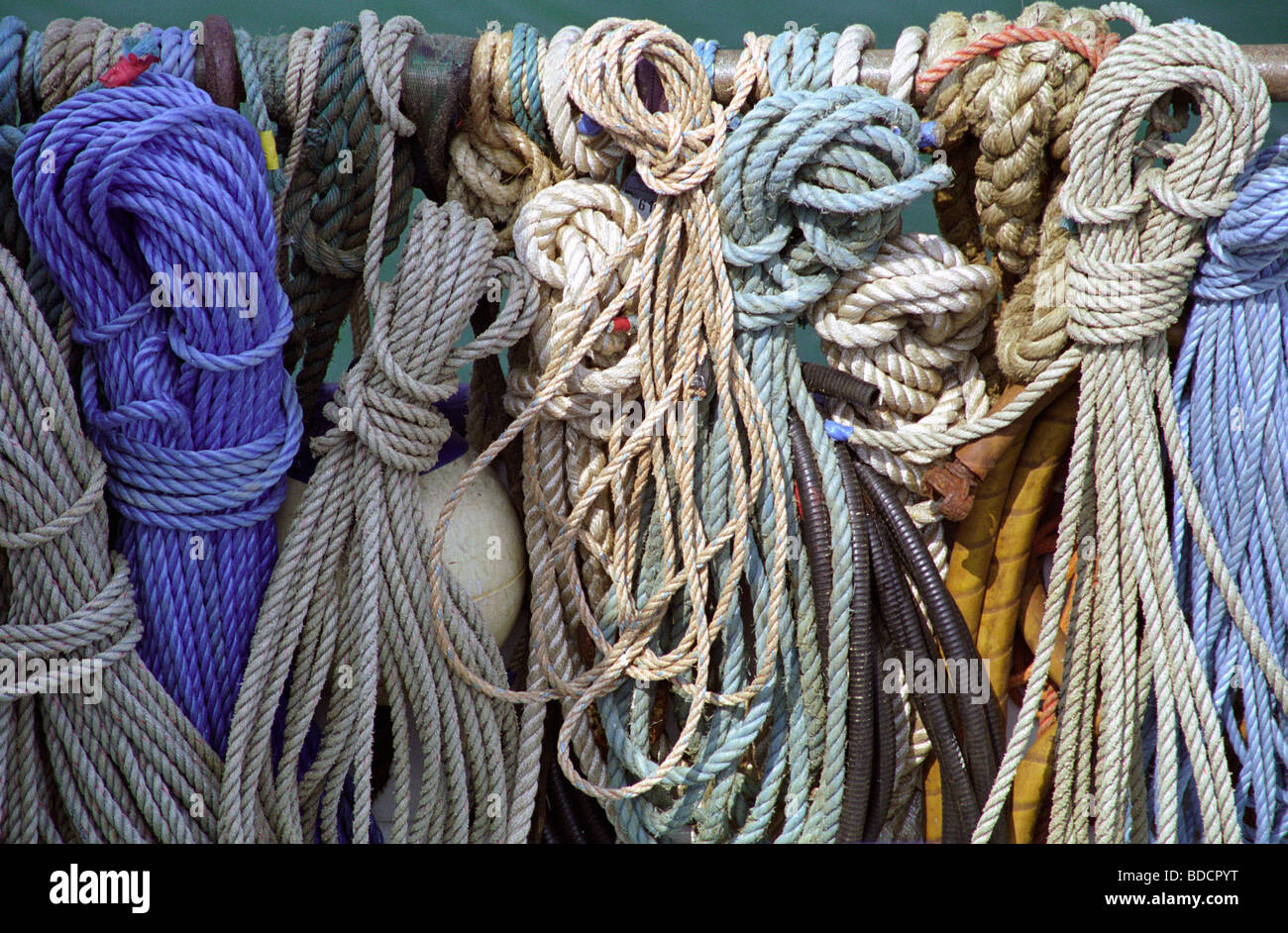 Coloured ropes coiled fishing boat lines on a fence, Weymouth Stock ...
