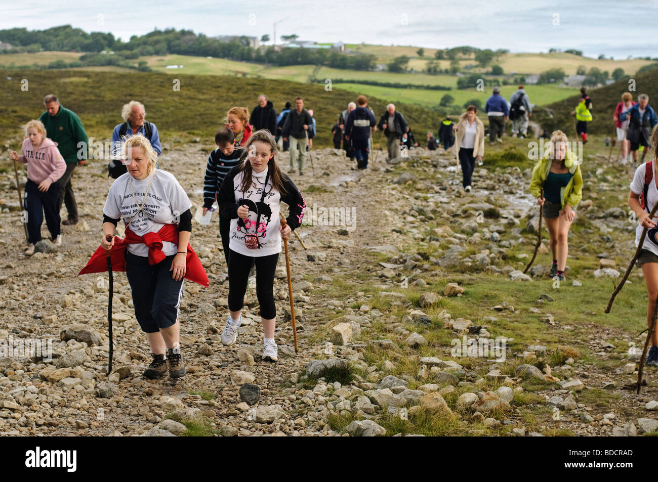Pilgrims with walking sticks climbing the foothills of Croagh Patrick ...