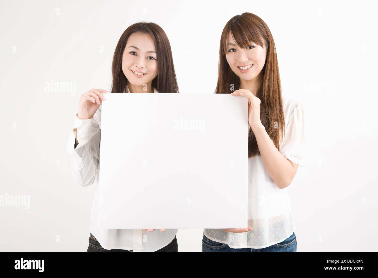 Two young women holding message board Stock Photo - Alamy