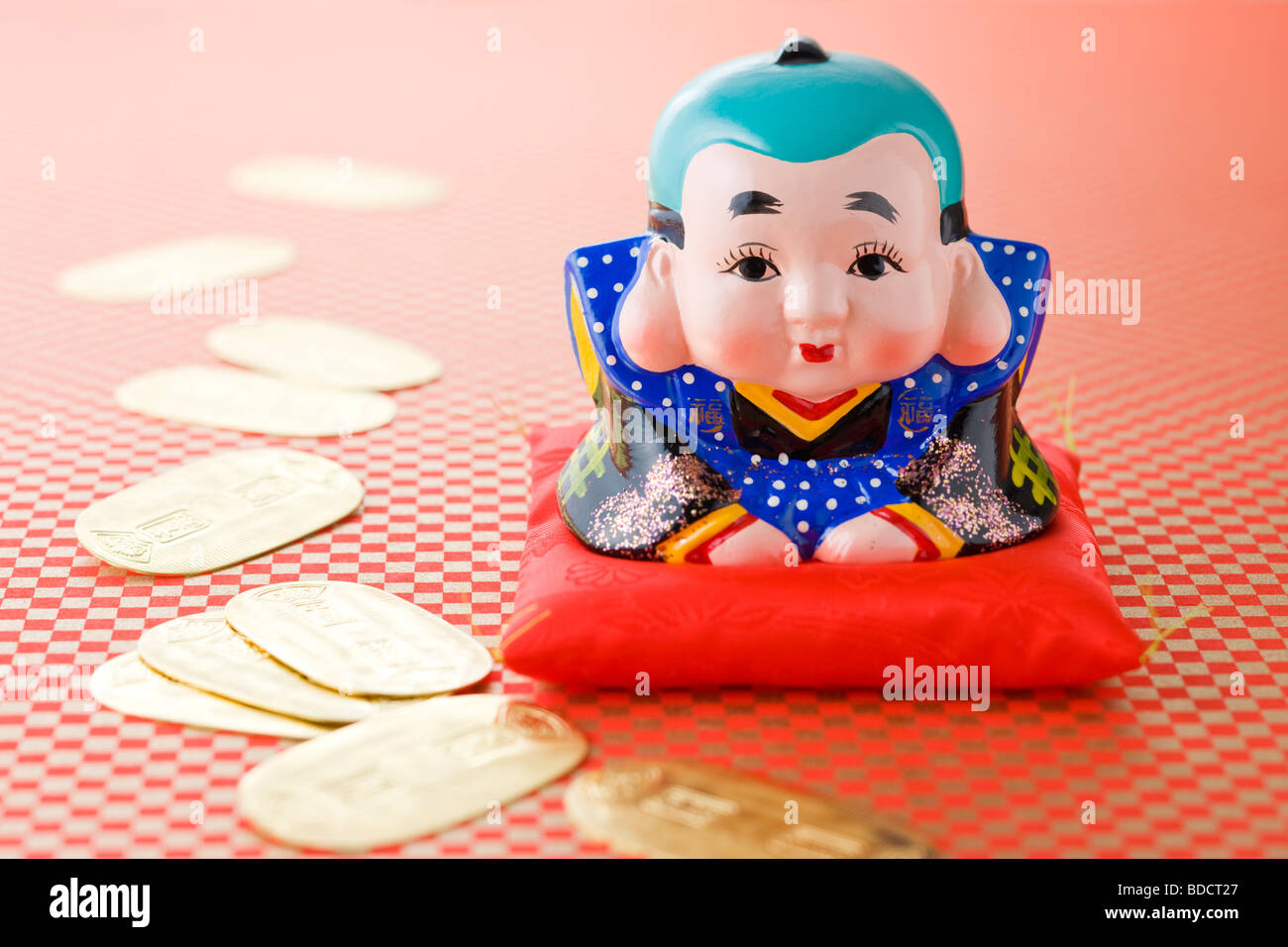 Fukusuke doll and gold coin Stock Photo - Alamy
