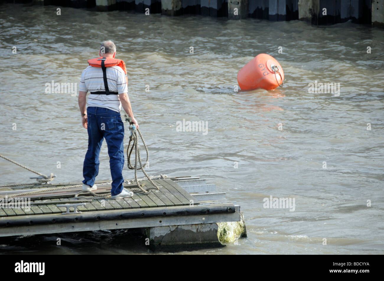 Man wearing life jacket about to catch buoy River Thames Greenwich ...