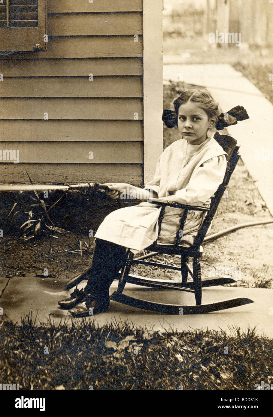 Little Girl Watering Garden from Rocking Chair Stock Photo - Alamy