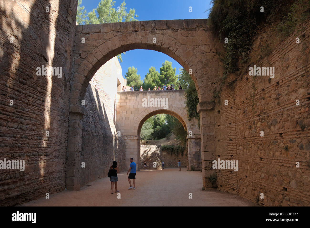 Tourists walk through the archways in the palace of Alhambra Stock ...