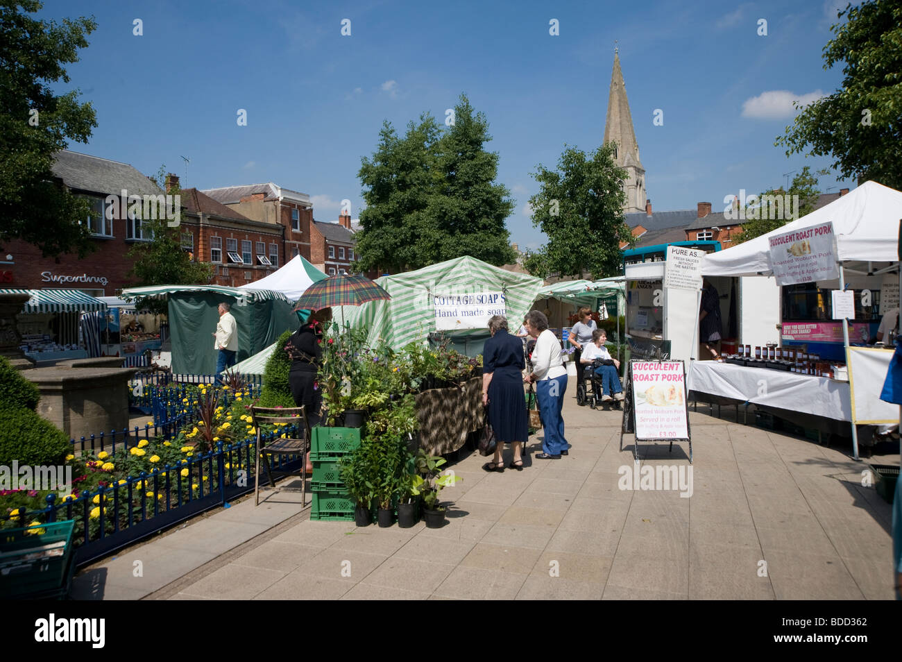 People and market stalls at a farmers market in the pretty market town ...