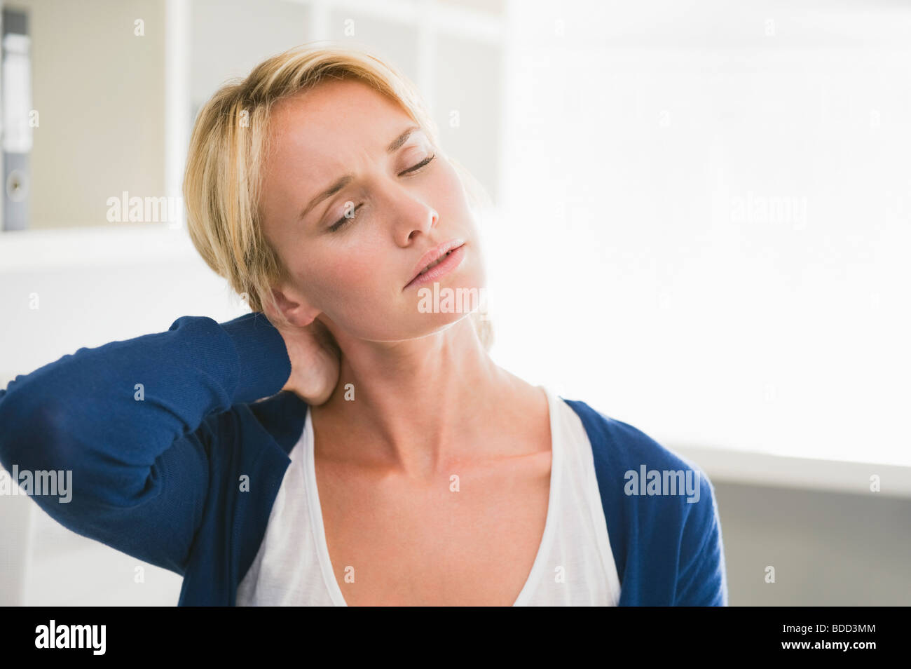 Woman touching her neck Stock Photo - Alamy