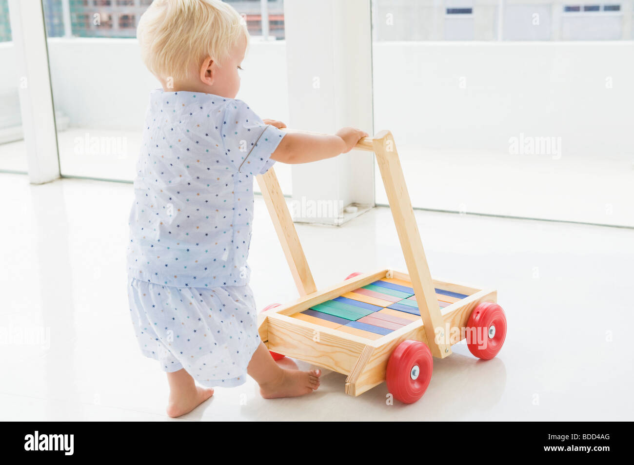 Baby boy pushing a cart Stock Photo - Alamy
