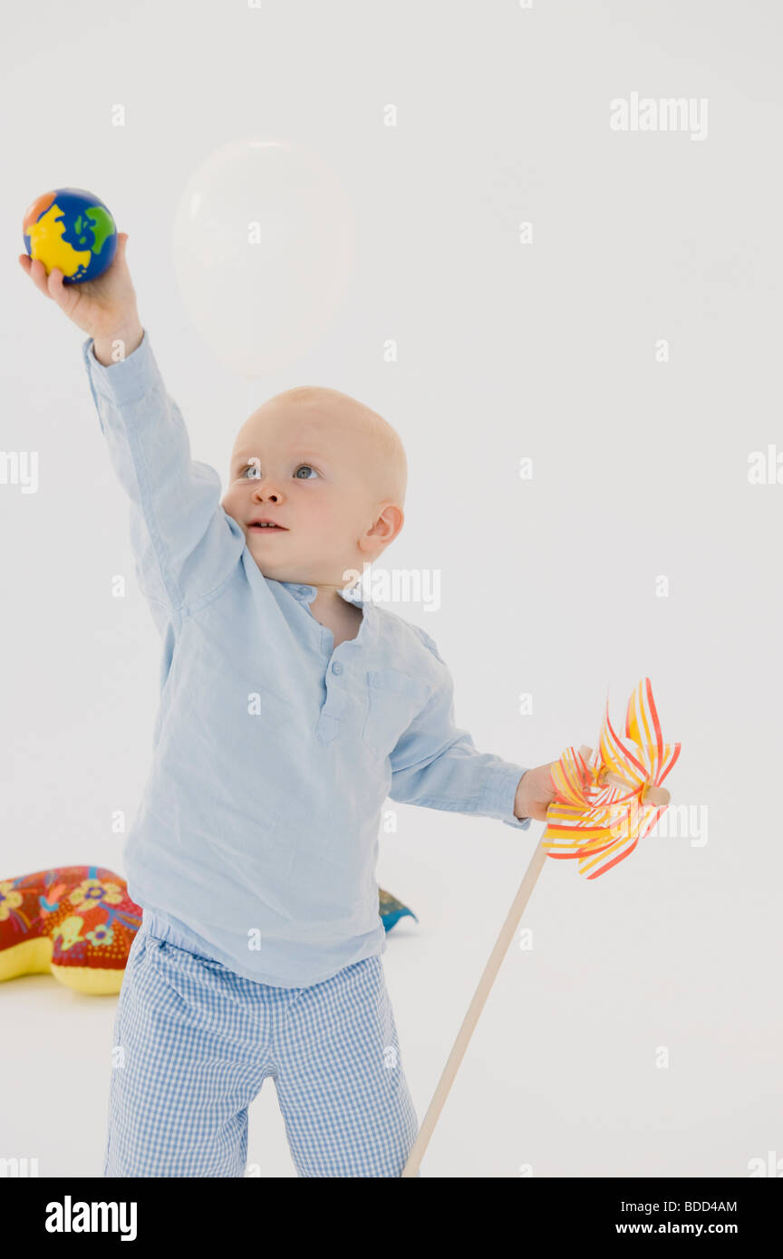 Baby boy holding up a ball Stock Photo - Alamy