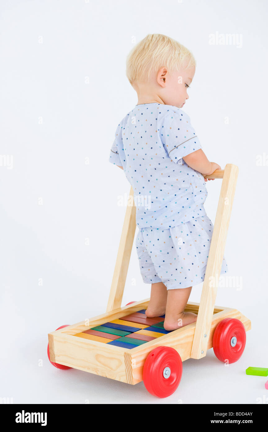 Baby boy playing with a push cart Stock Photo - Alamy