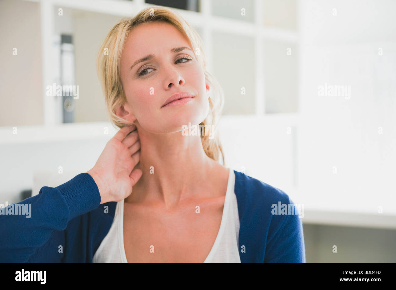 Woman touching her neck Stock Photo - Alamy