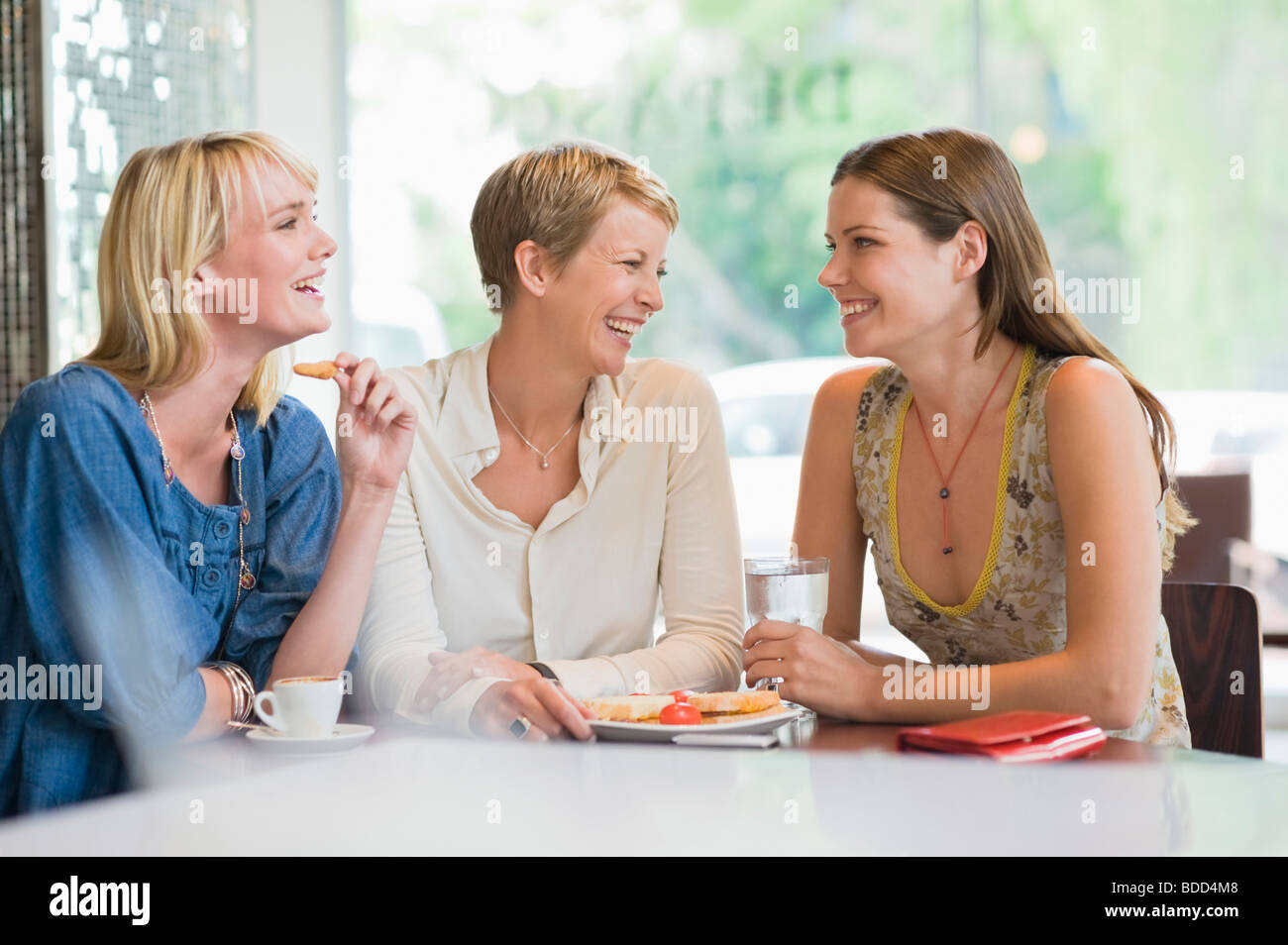 Three women sitting in a restaurant Stock Photo - Alamy