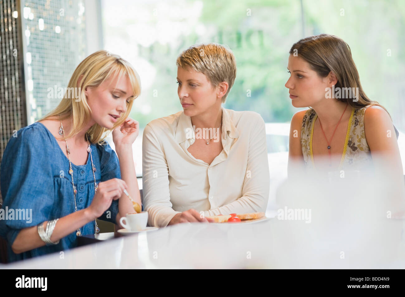 Three women sitting in a restaurant Stock Photo - Alamy